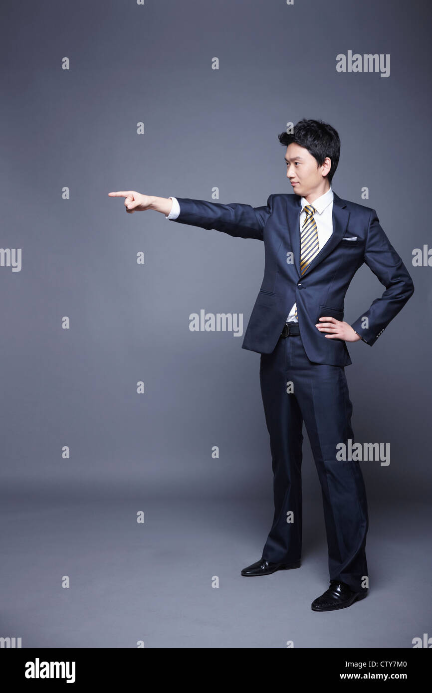 A businessman pointing at the front side Stock Photo - Alamy