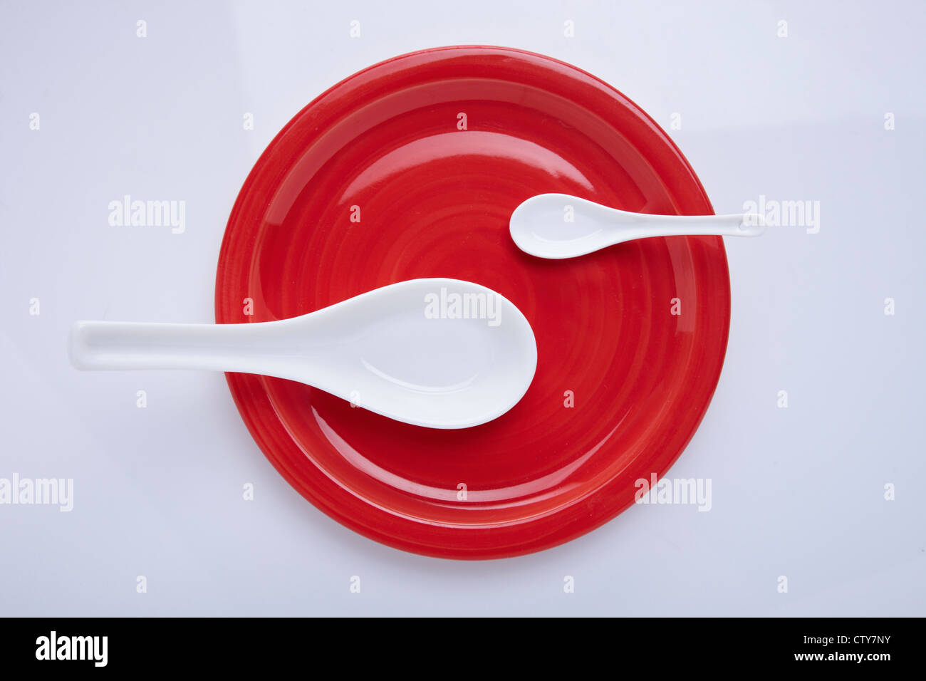 A big and small spoon on the dish Stock Photo - Alamy