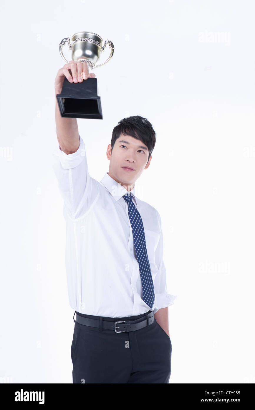 A man holding up a trophy Stock Photo - Alamy