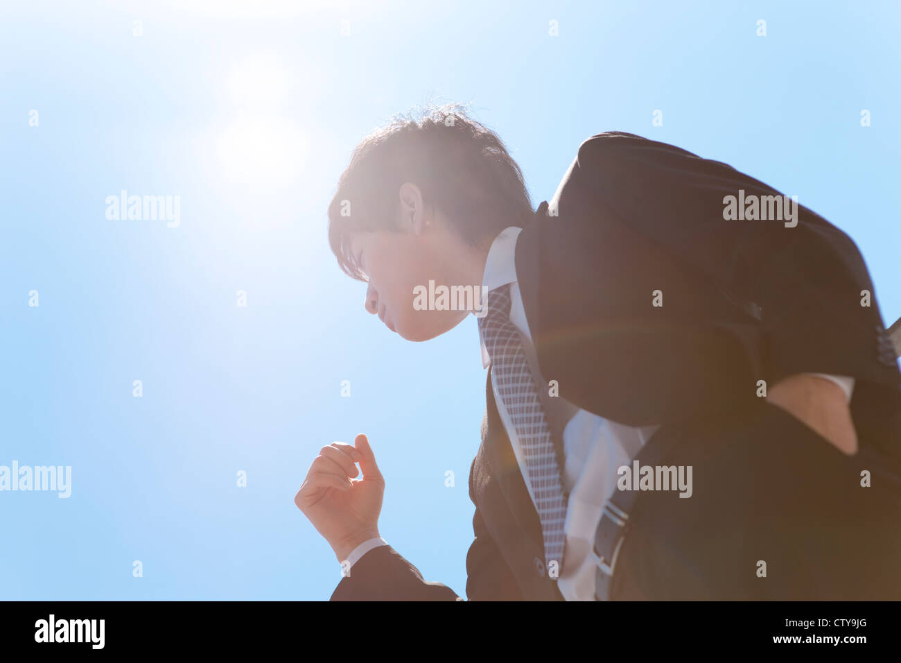 Businessman standing under the sun Stock Photo - Alamy