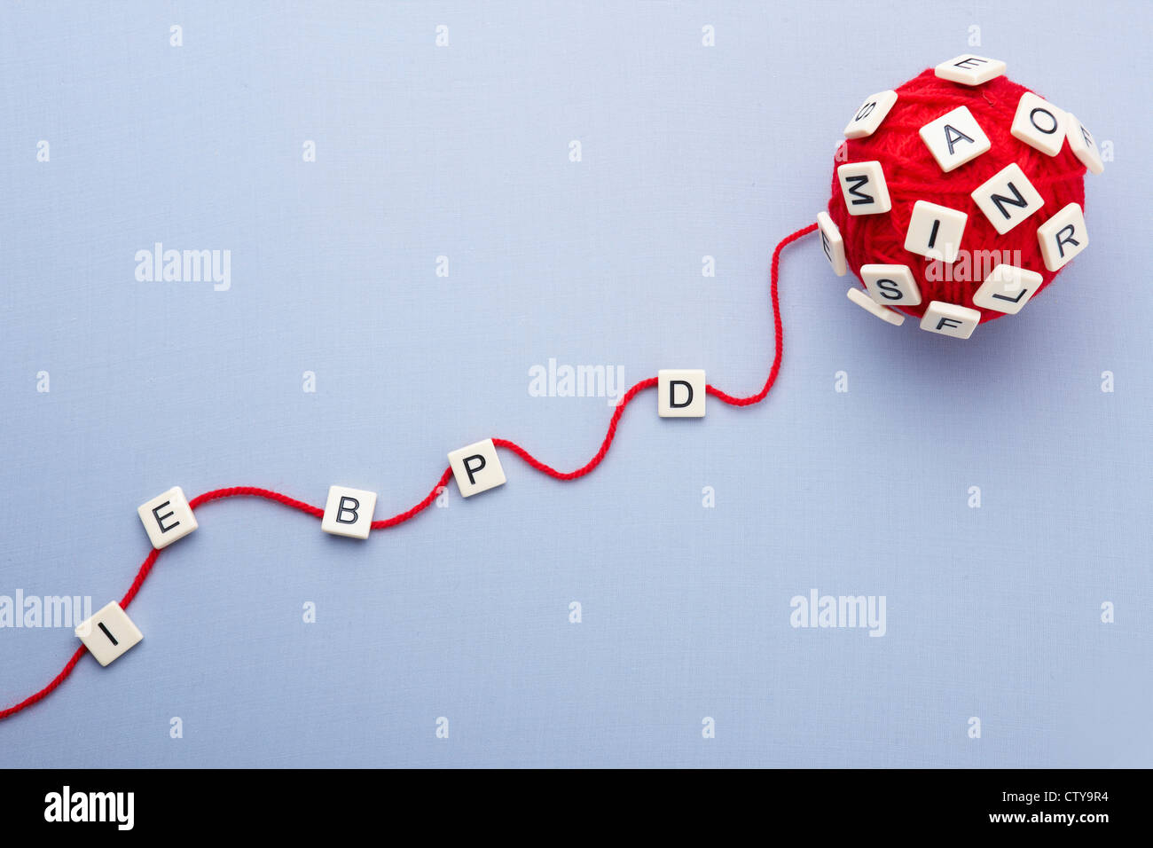 Alphabet blocks on a ball of red wool Stock Photo - Alamy