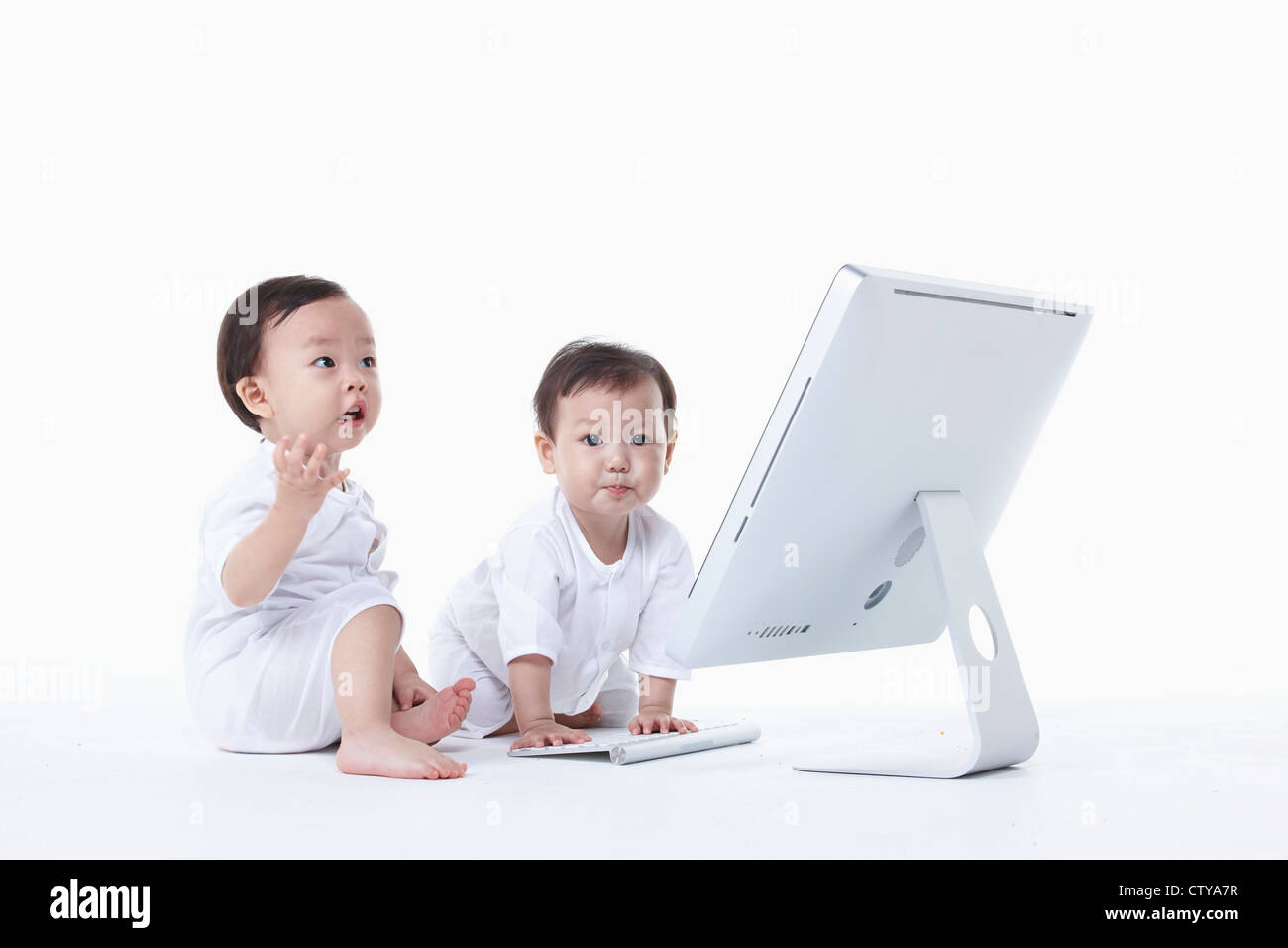 Babies sitting with a computer Stock Photo - Alamy