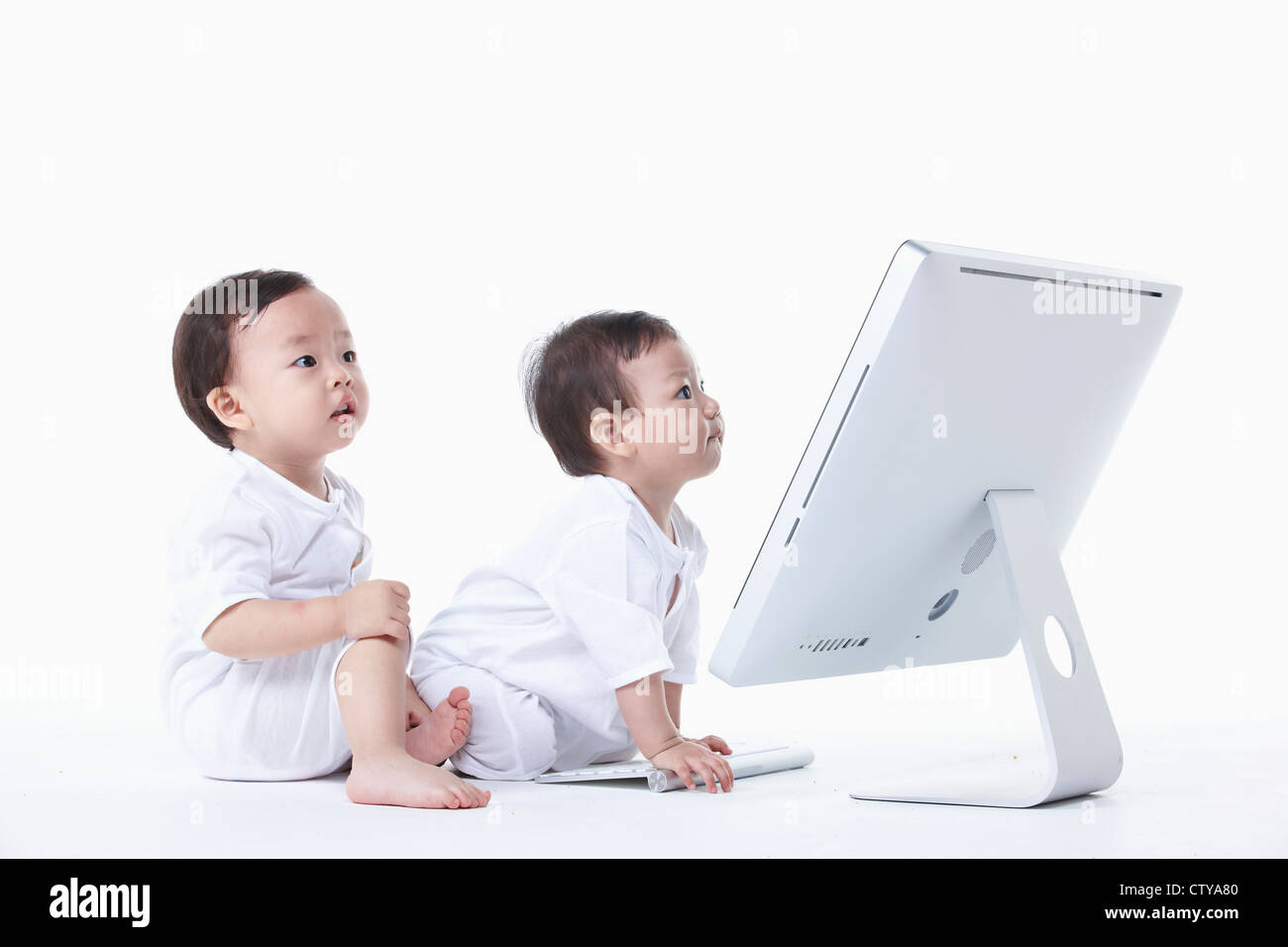 Babies sitting with a computer Stock Photo - Alamy