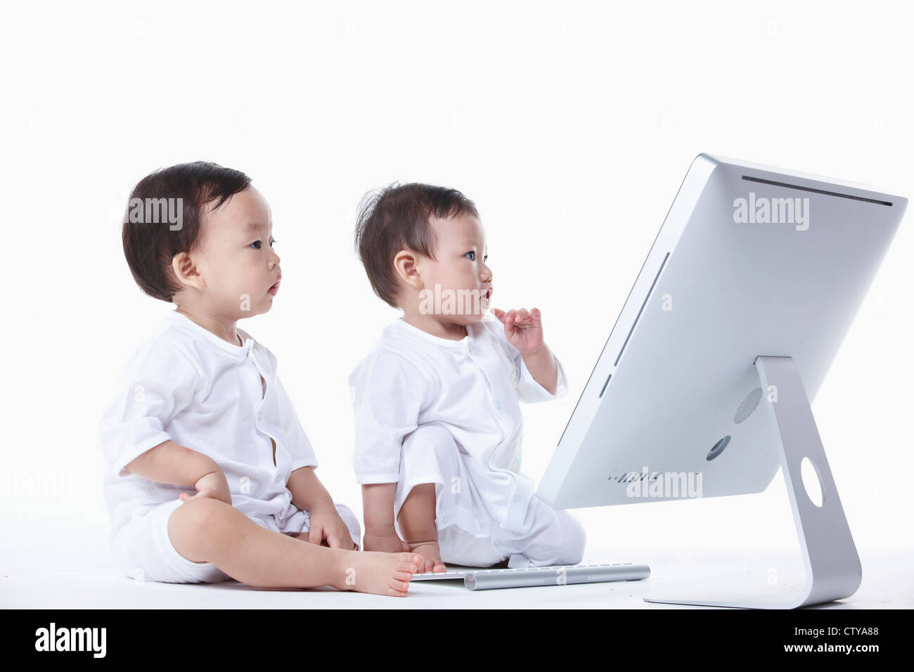 Babies sitting with a computer Stock Photo - Alamy