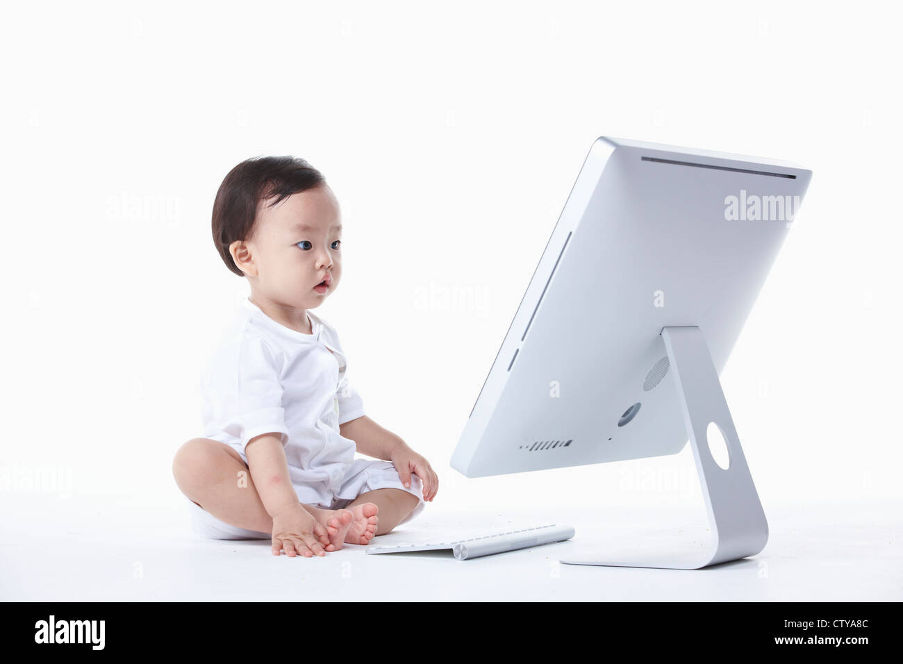 A baby sitting with a computer Stock Photo - Alamy