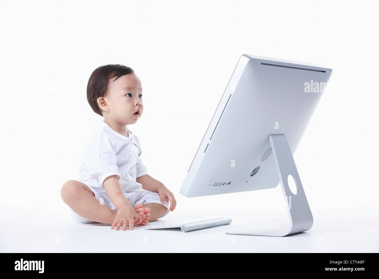 A baby sitting with a computer Stock Photo - Alamy