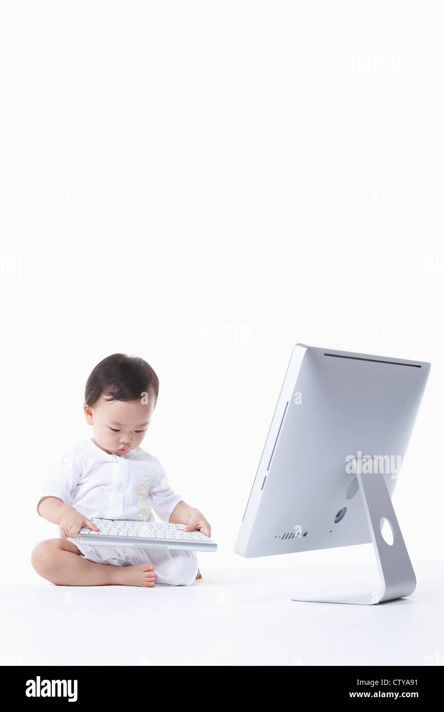 A baby holding the keyboard Stock Photo - Alamy