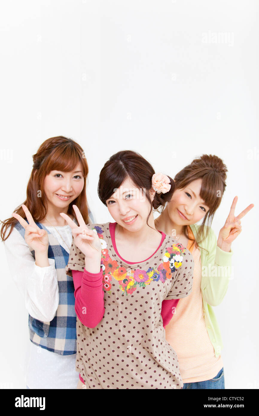 Three women making a peace sign Stock Photo - Alamy