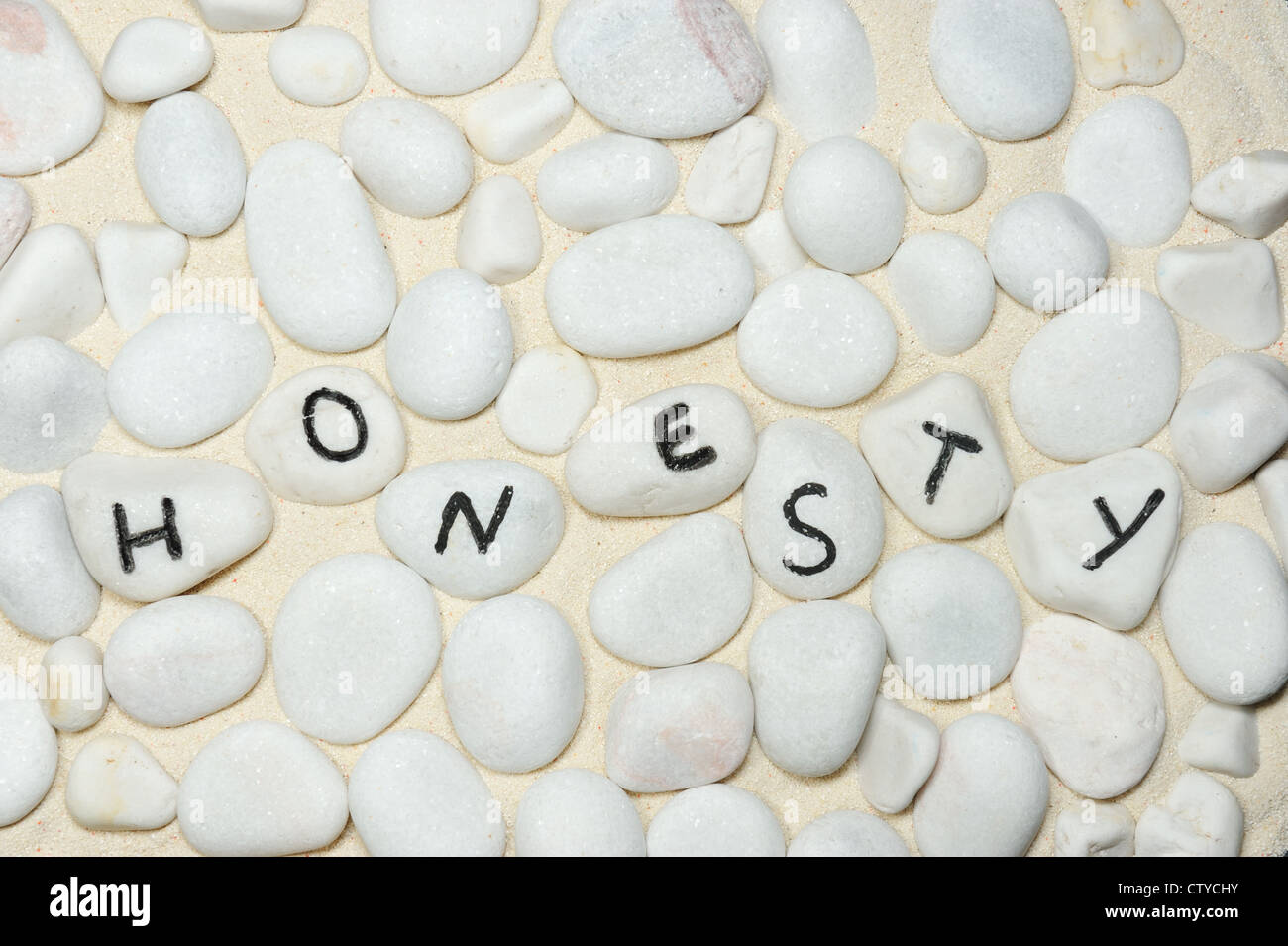 Honesty word on group of stones on the sand Stock Photo - Alamy