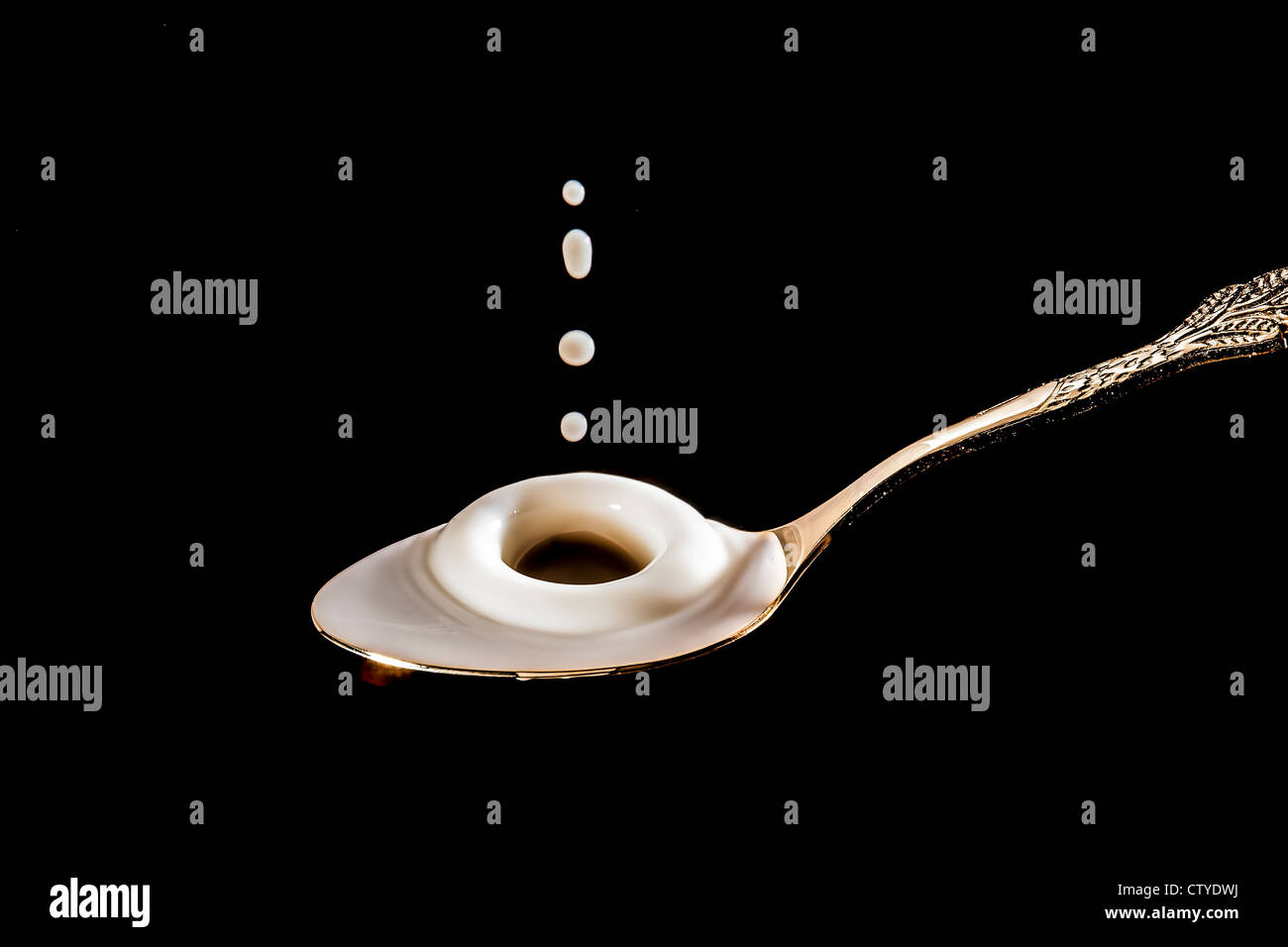 milk being dripped into a gold baby spoon Stock Photo - Alamy