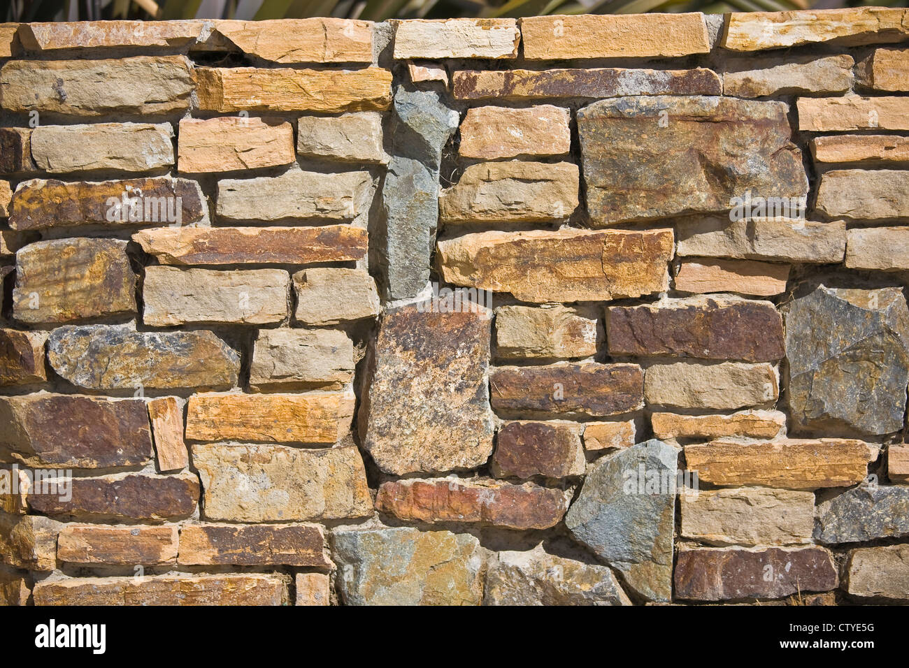 Stone wall of various shapes and colors of stones Stock Photo - Alamy