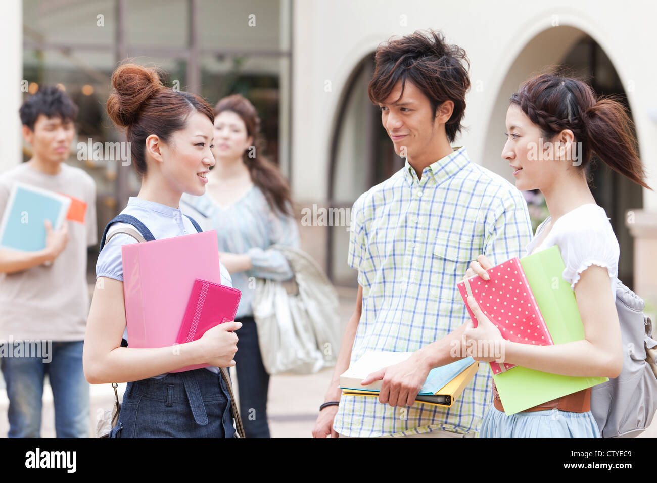 Three university students talking Stock Photo - Alamy