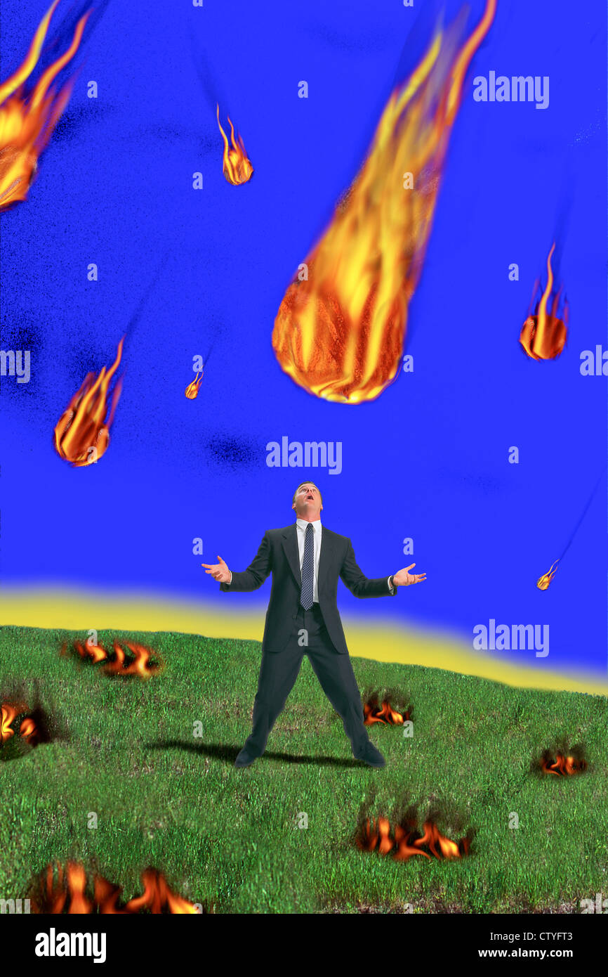 Businessman hit balls of fire from sky Stock Photo - Alamy