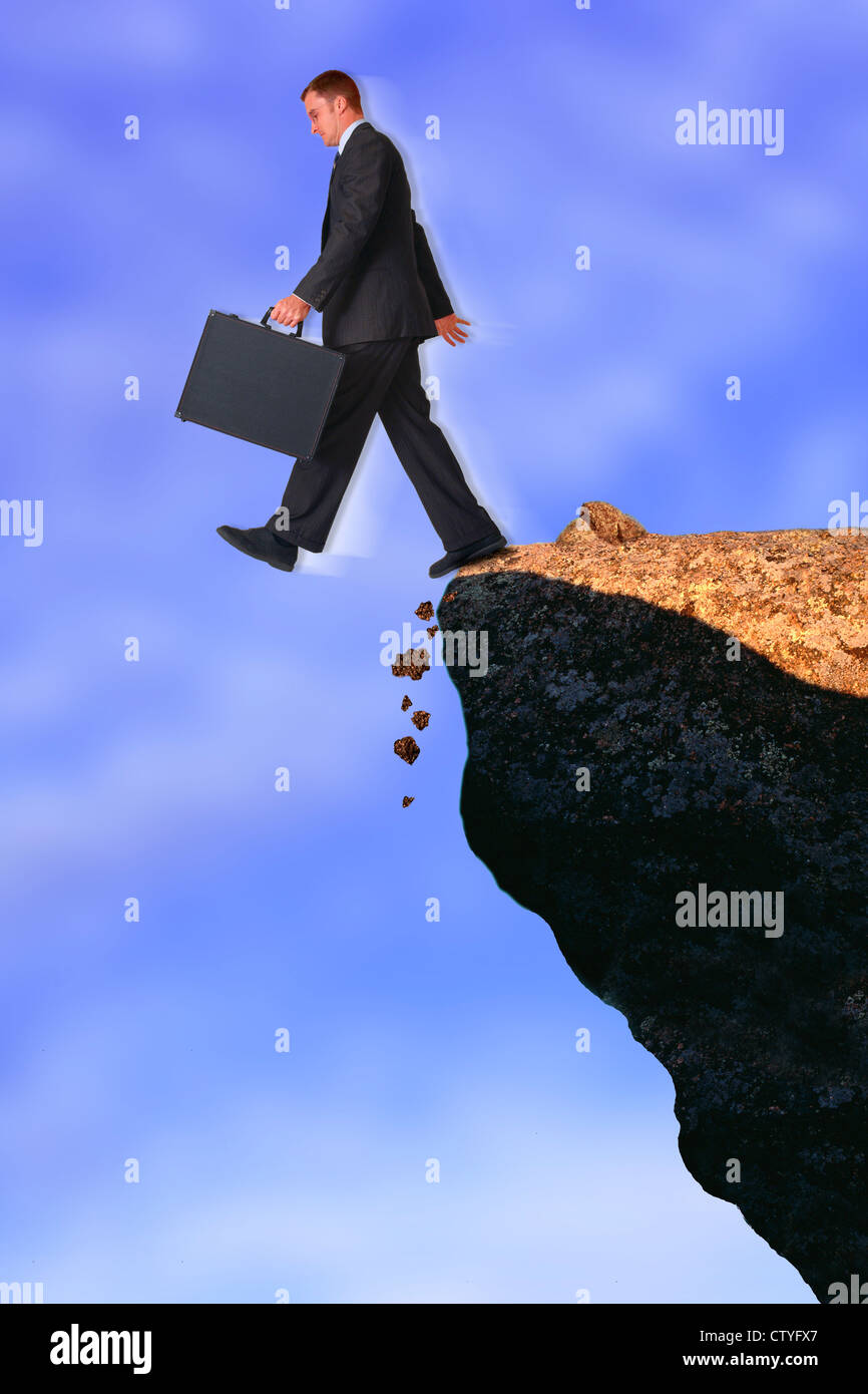 Businessman walking off rocky cliff Stock Photo - Alamy