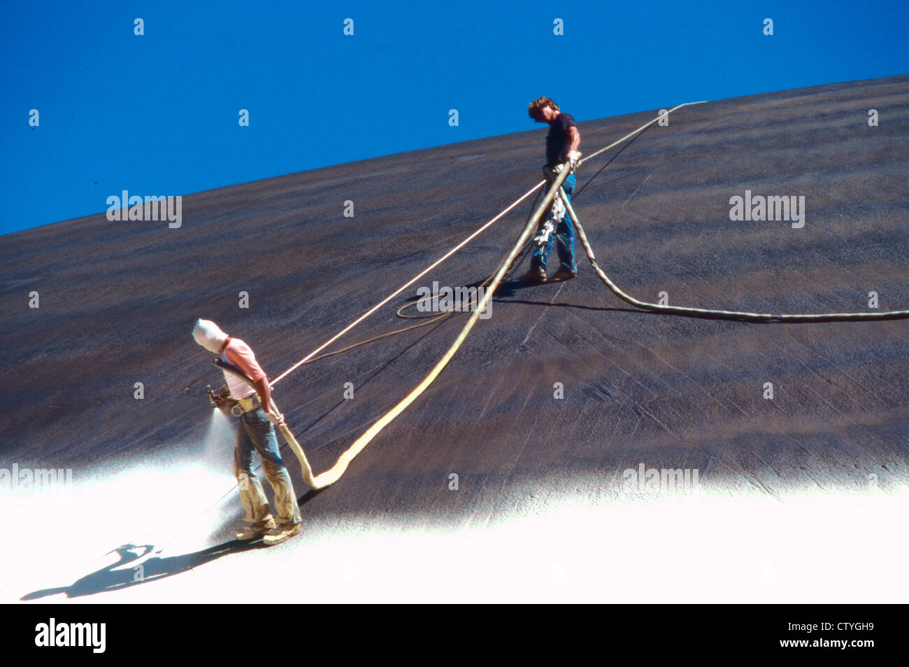 two men spraying paint Stock Photo - Alamy