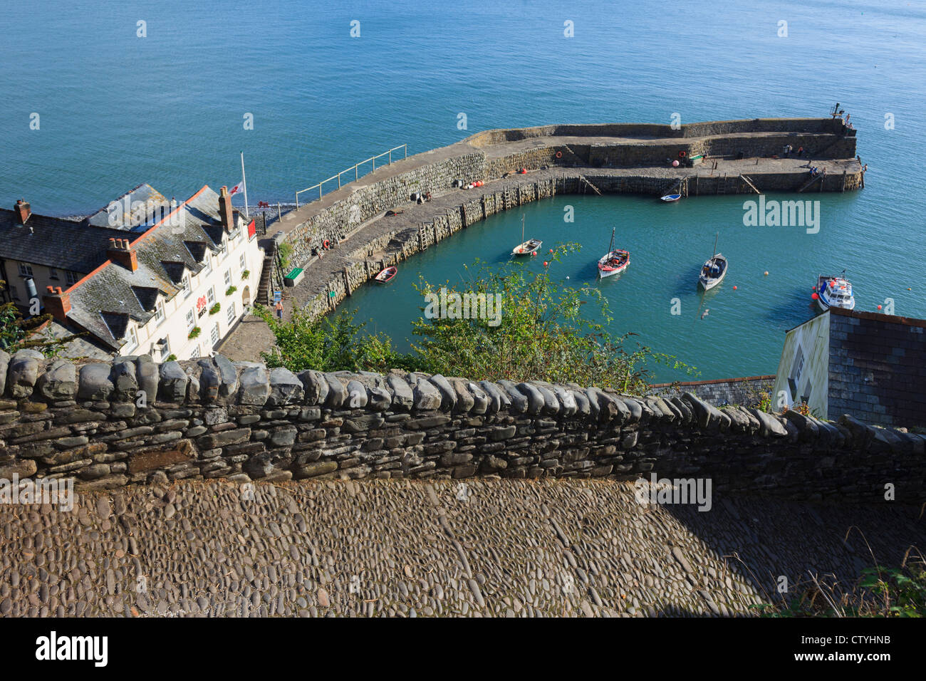 View down to small village fishing harbour from steep narrow cobbled ...