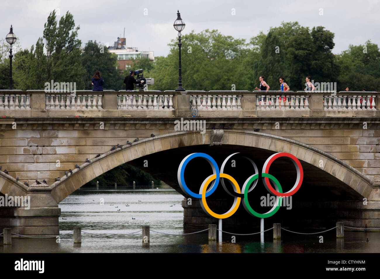 Triathletes run over Serpentine Bridge in London's Hyde Park for the ...