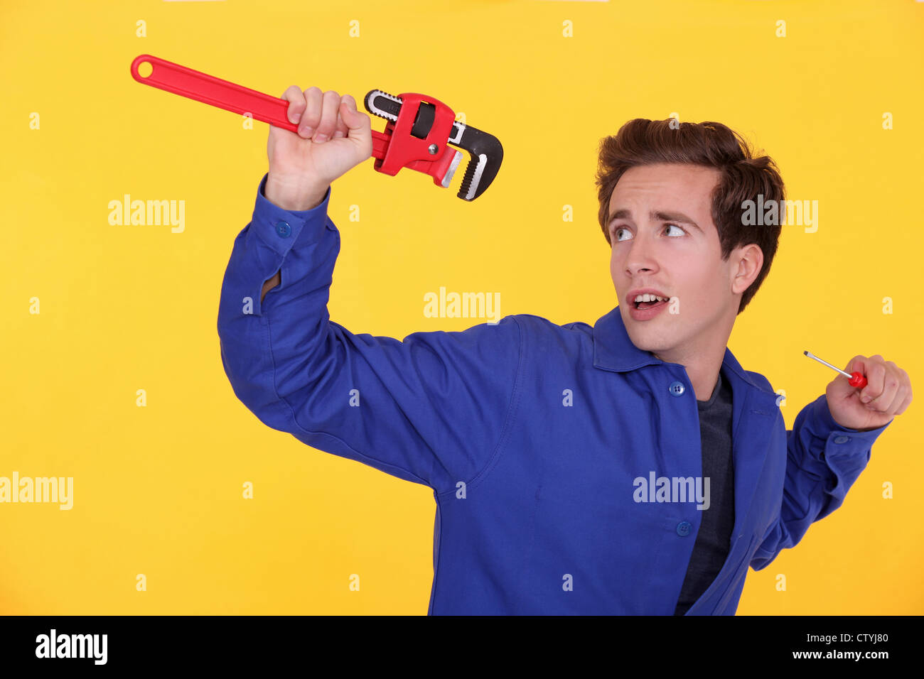 Man with a wrench and screwdriver Stock Photo - Alamy