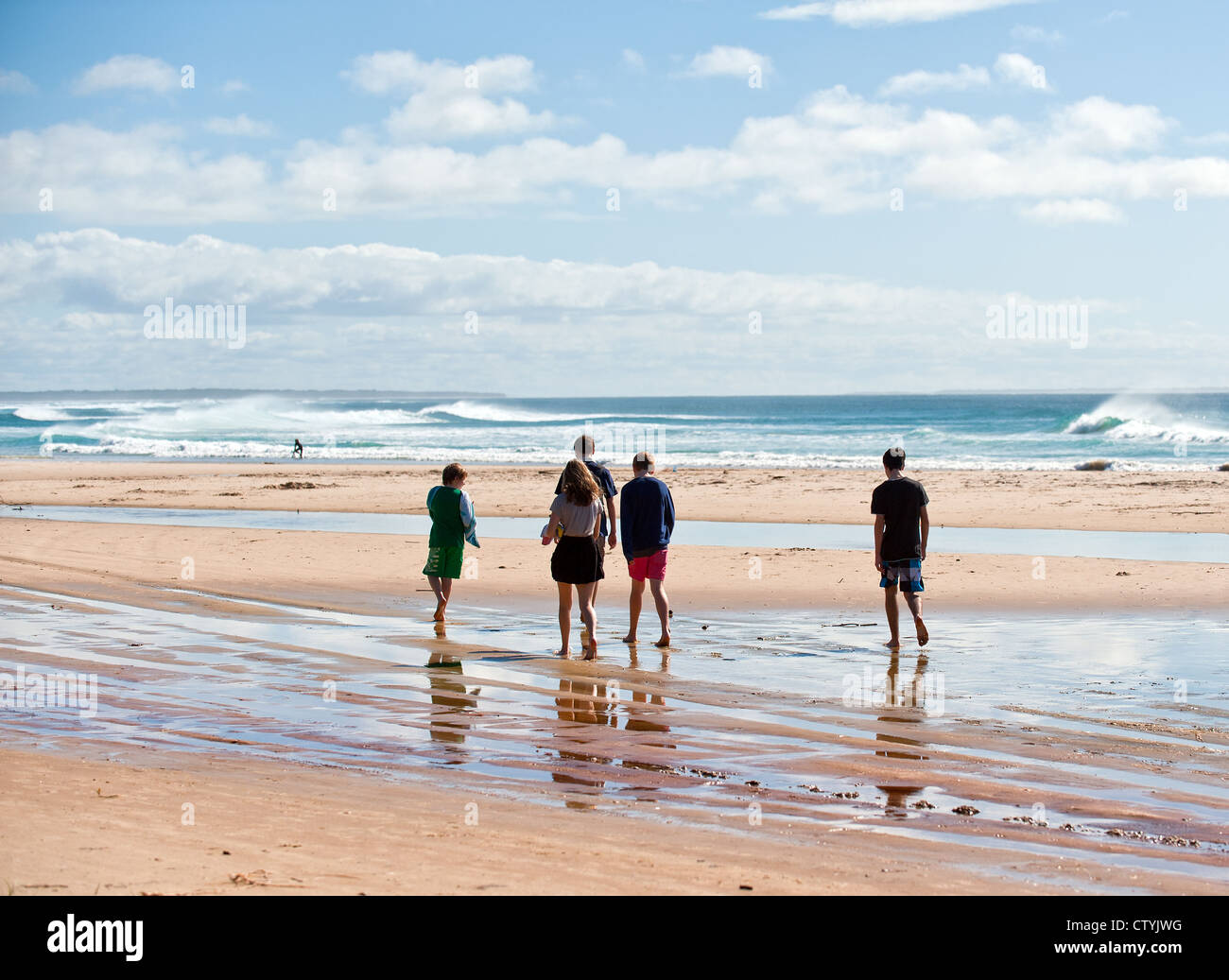 A group of tourists walking on Cylinder Beach on North Stradbroke ...