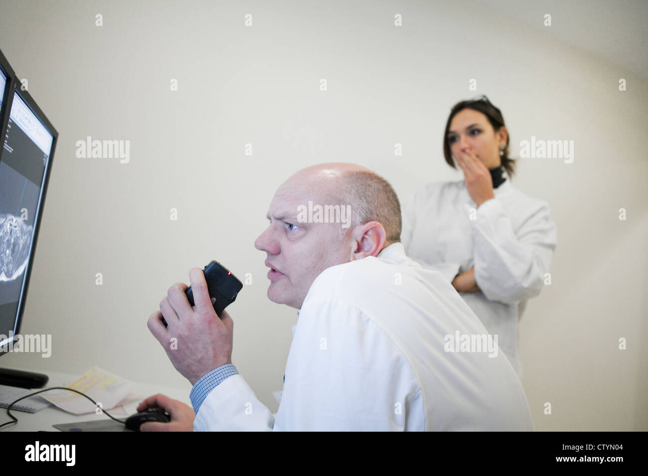 Radiologist and a female colleague examines MRI scan on monitor Stock ...