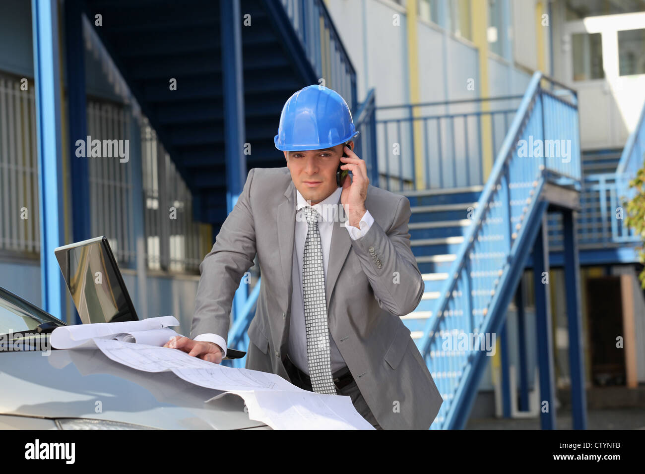 Architect on site with plans and cellphone Stock Photo - Alamy