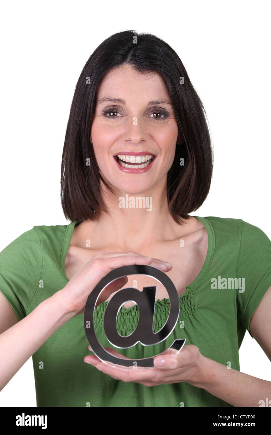 Smiling woman holding the arobase sign Stock Photo - Alamy