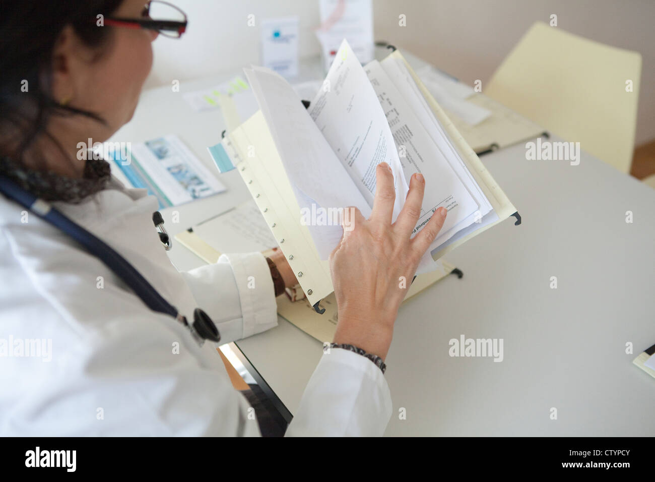Female doctor sorting out paperwork Stock Photo - Alamy