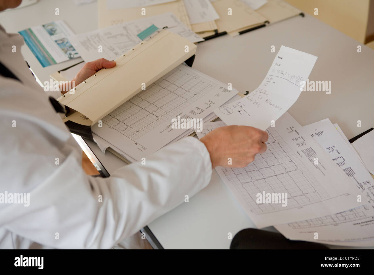 Doctor sorting-out paperwork-close-up Stock Photo - Alamy
