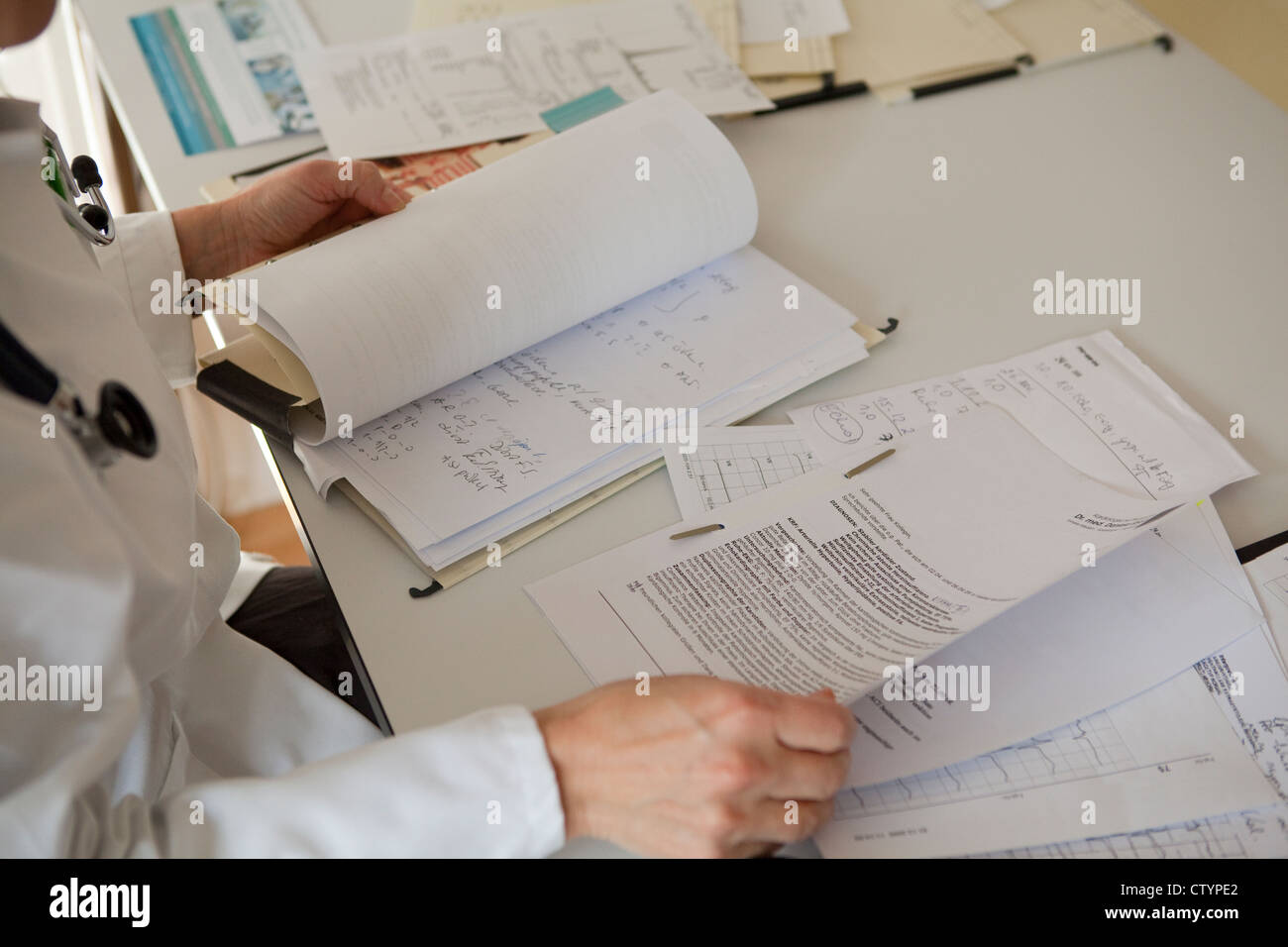 Doctor sorting-out paperwork on her desk Stock Photo - Alamy