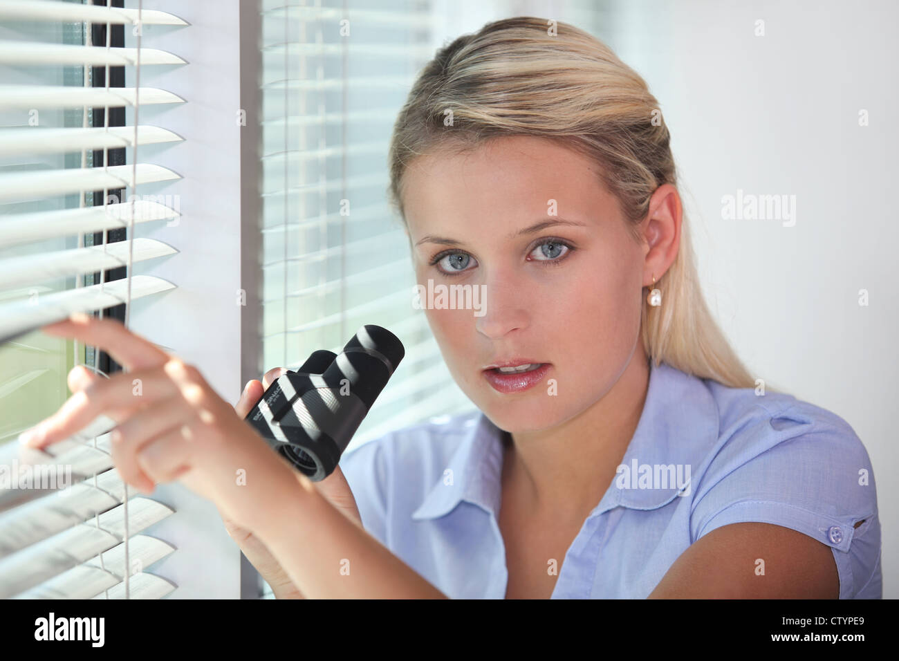 Woman peering through curtains hi-res stock photography and images - Alamy