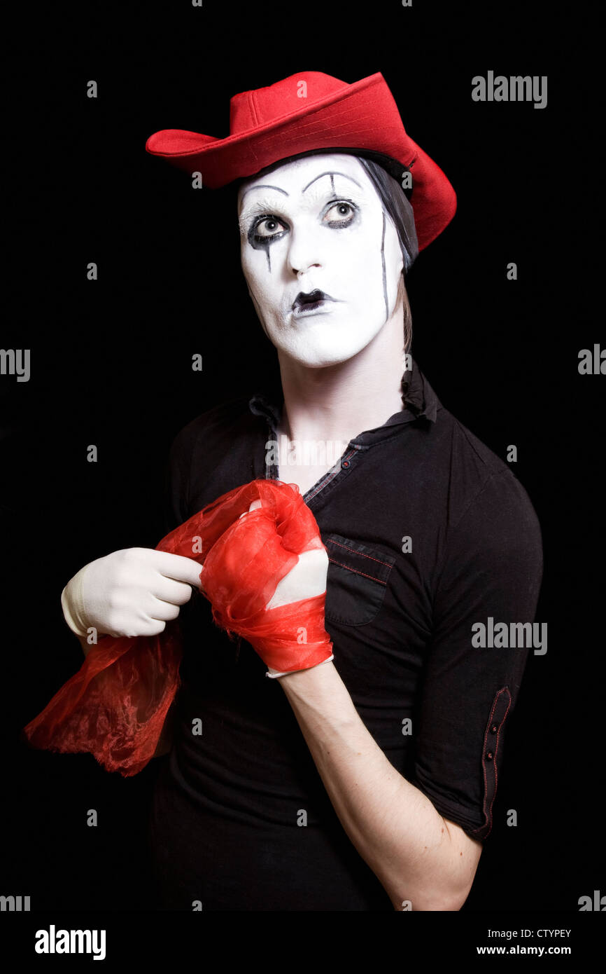 Mime in a red cowboy hat on a black background Stock Photo - Alamy