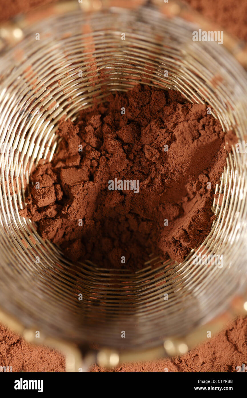 cocoa powder in old rustic style silver sieve, shallow dof, top view ...