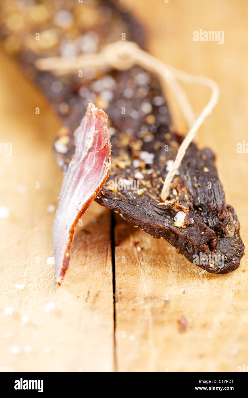 Biltong - dry cured beef meat with slice Stock Photo - Alamy