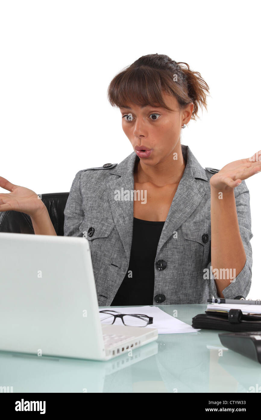 Confused businesswoman sat at desk Stock Photo - Alamy