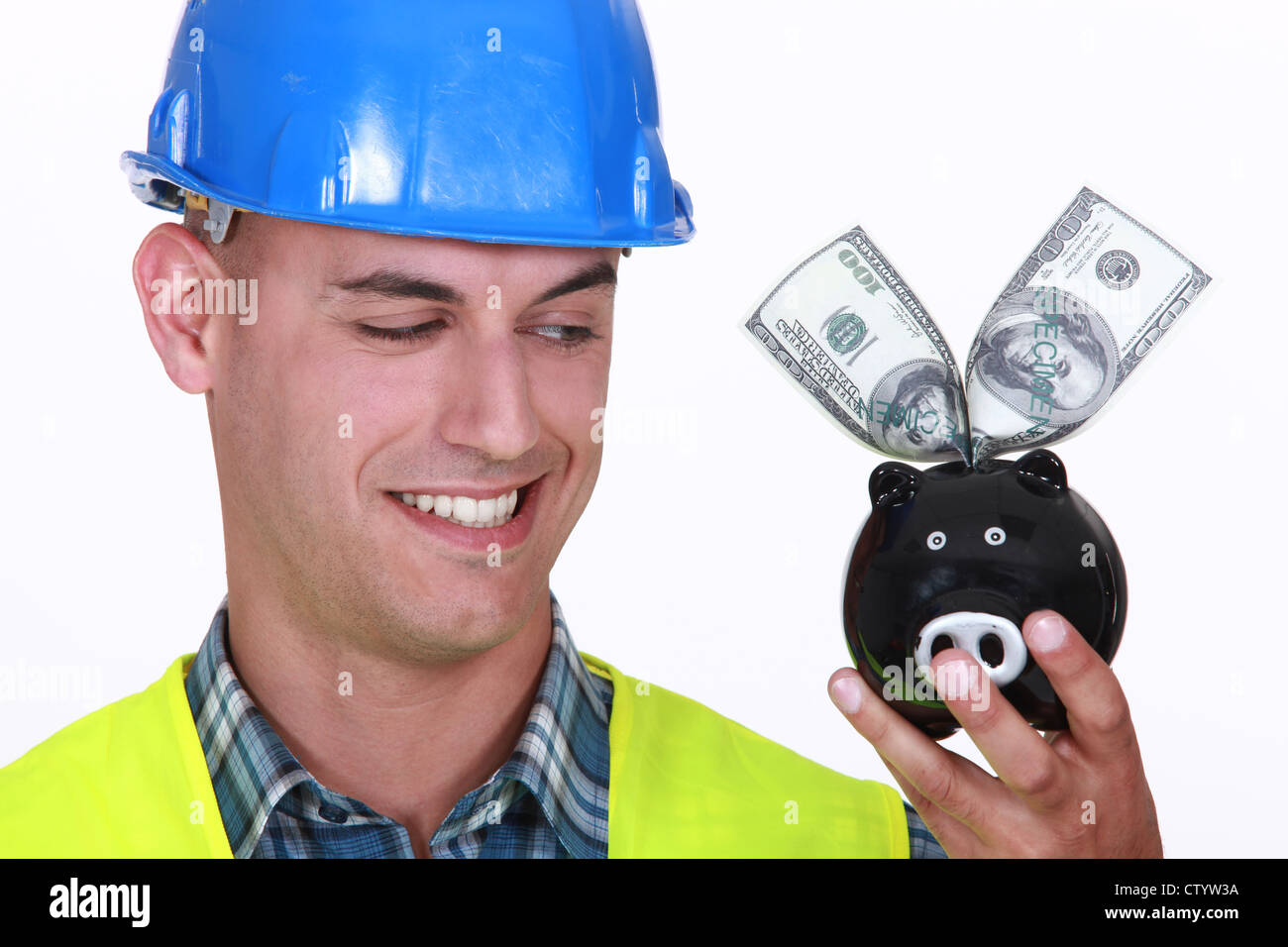 Construction worker with money in a piggy bank Stock Photo - Alamy