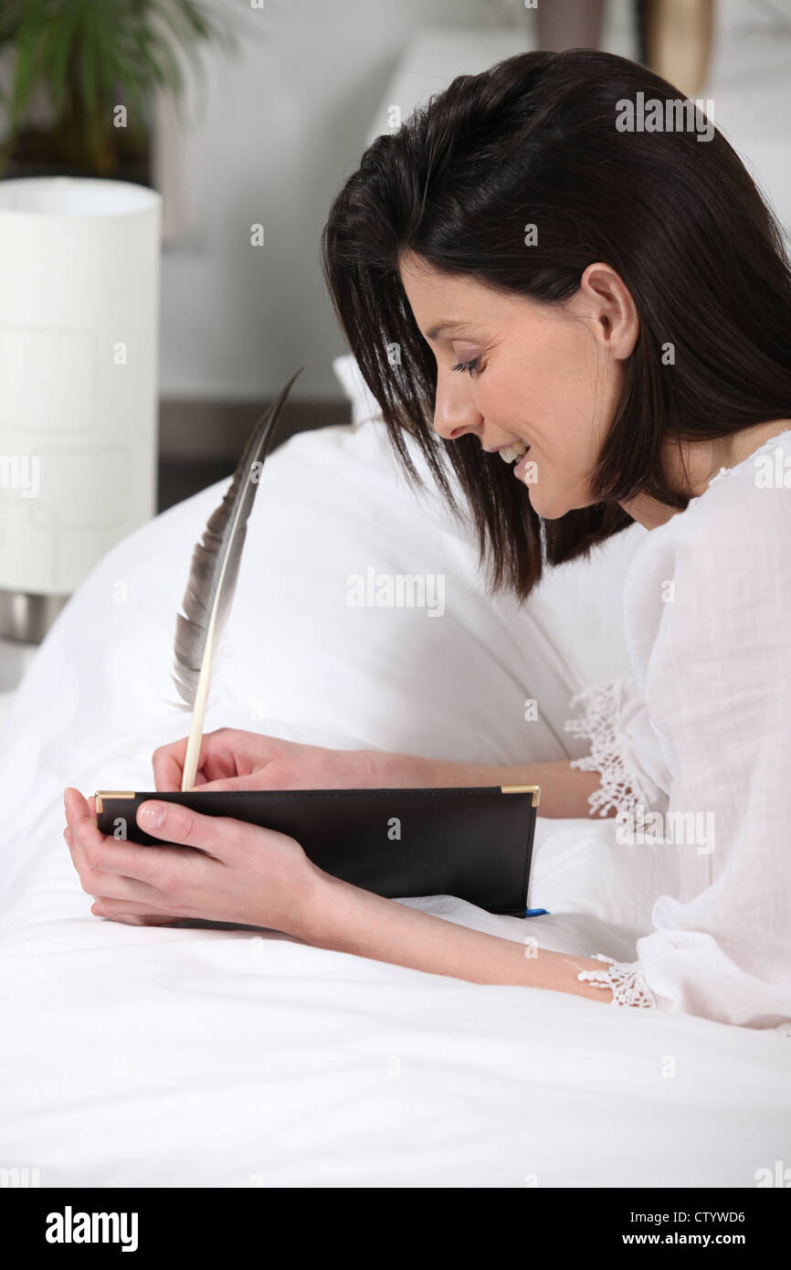 Woman writing with feather Stock Photo - Alamy