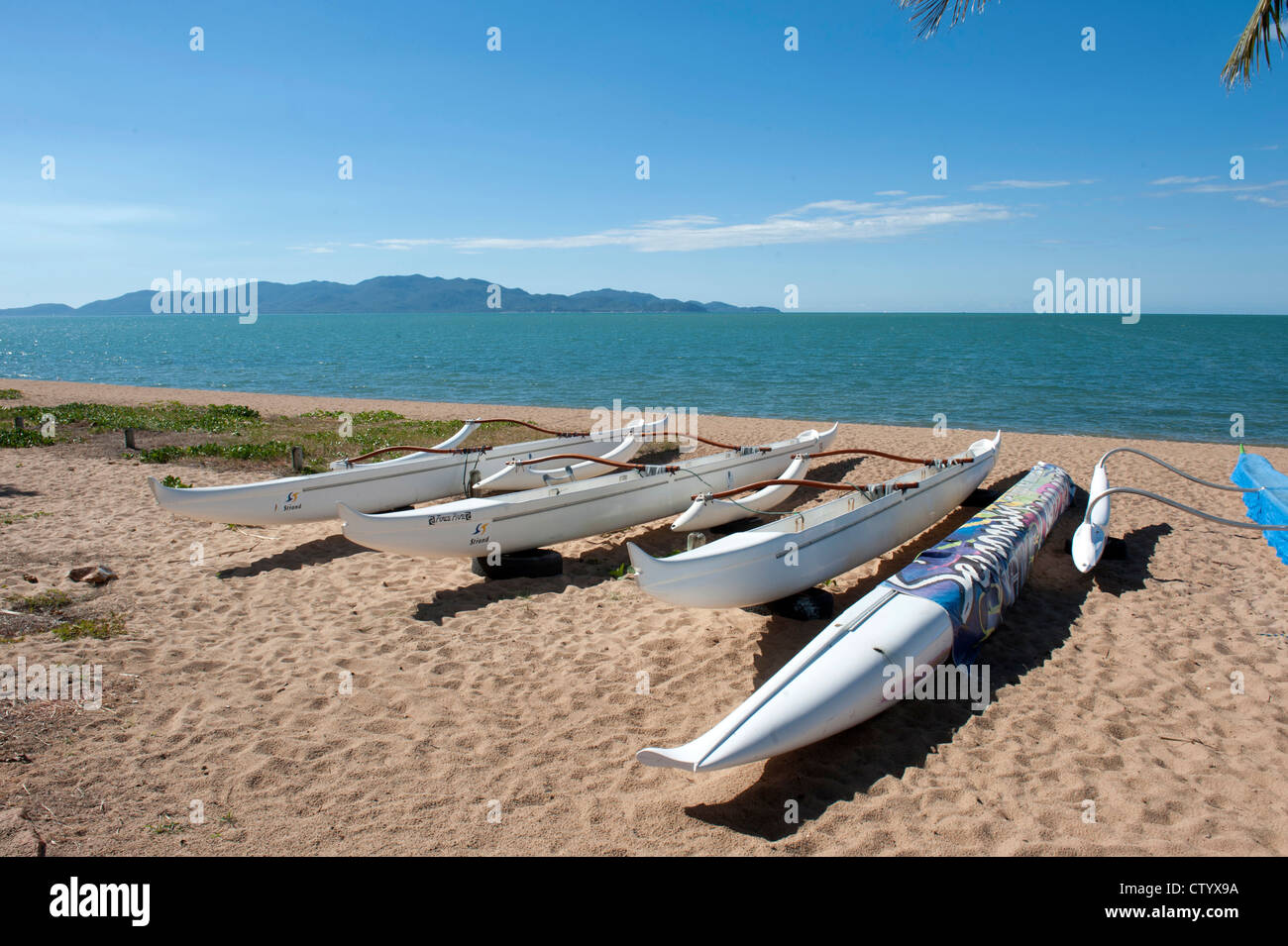 Outrigger canoes resting on the beach of The Strand at Townsville with ...