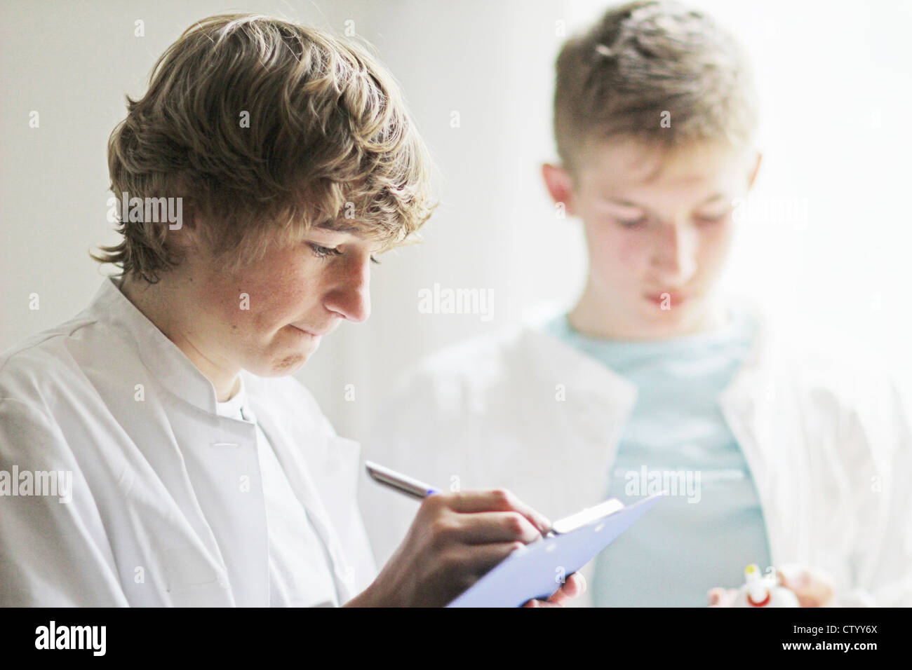 Students writing in classroom Stock Photo - Alamy