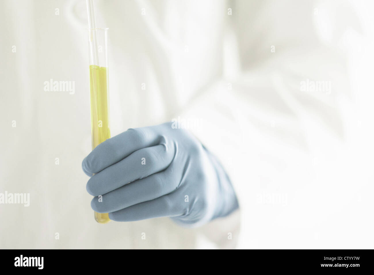 Gloved hand holding test tube Stock Photo - Alamy