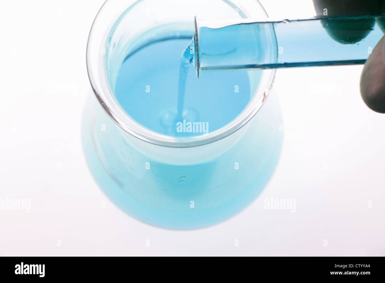 Close up of liquid pouring into beaker Stock Photo - Alamy