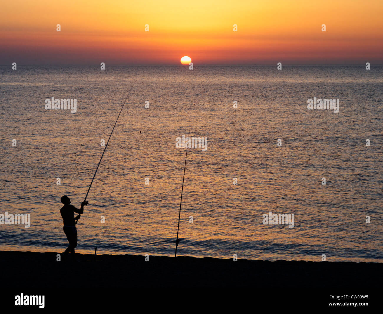 Man fishing in the sunset Stock Photo - Alamy