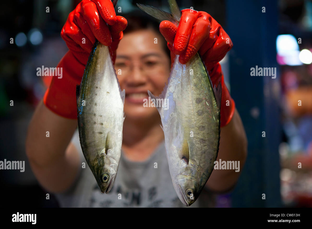 Woman holding up fish in Tai Po Market, New Territories, Hong Kong ...