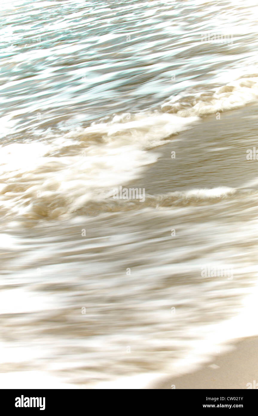 tropical beach scene showing waves lapping at the shore Stock Photo - Alamy