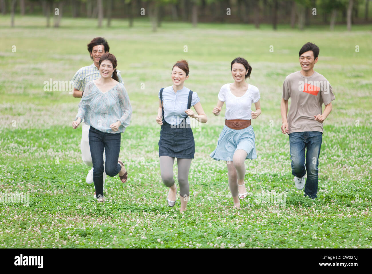 Young people running on grass Stock Photo - Alamy