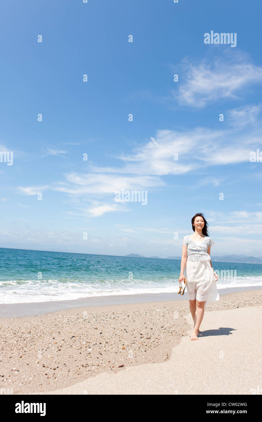 Woman walking on beach Stock Photo - Alamy