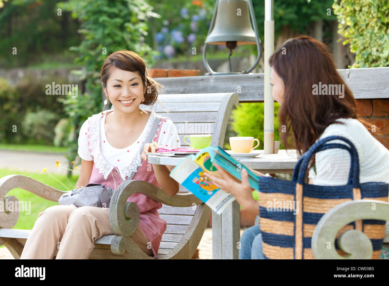 Young women reading tour book Stock Photo - Alamy