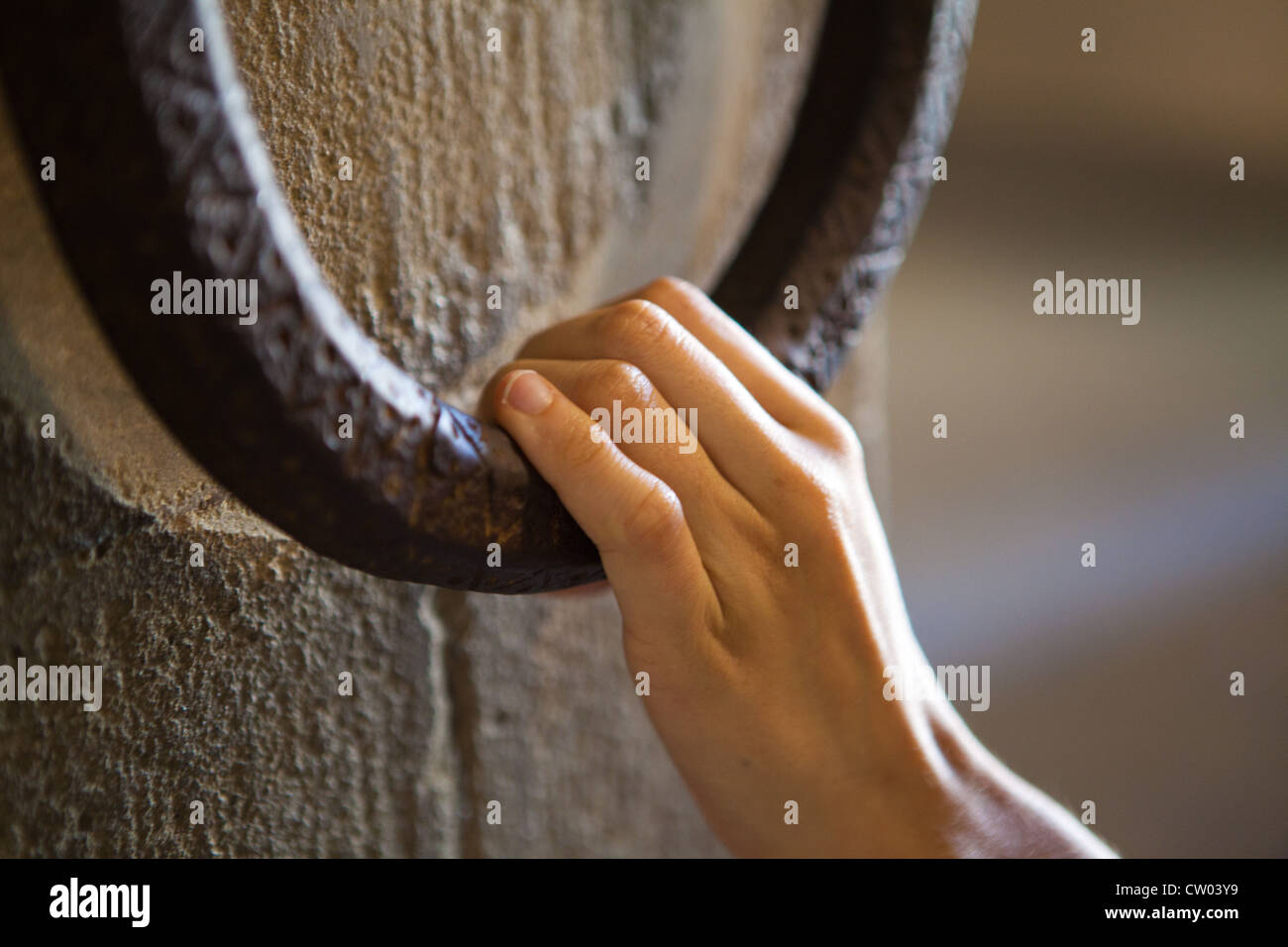 A woman is knocking on an old metal clapper Stock Photo - Alamy