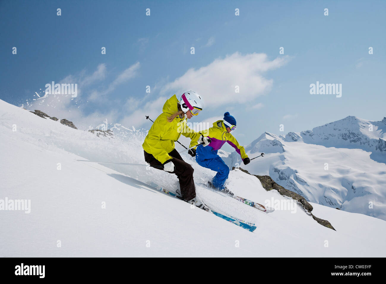 Skiers coasting on snowy slope Stock Photo - Alamy