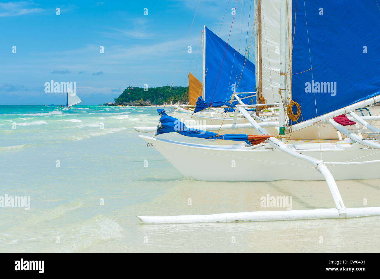 traditional paraw sailing boats on white beach on boracay island ...