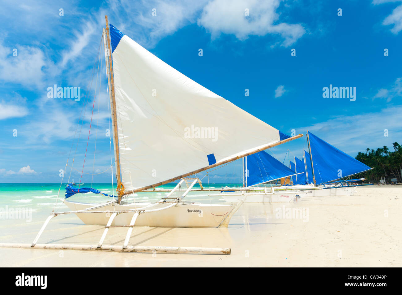 traditional paraw sailing boats on white beach on boracay island ...
